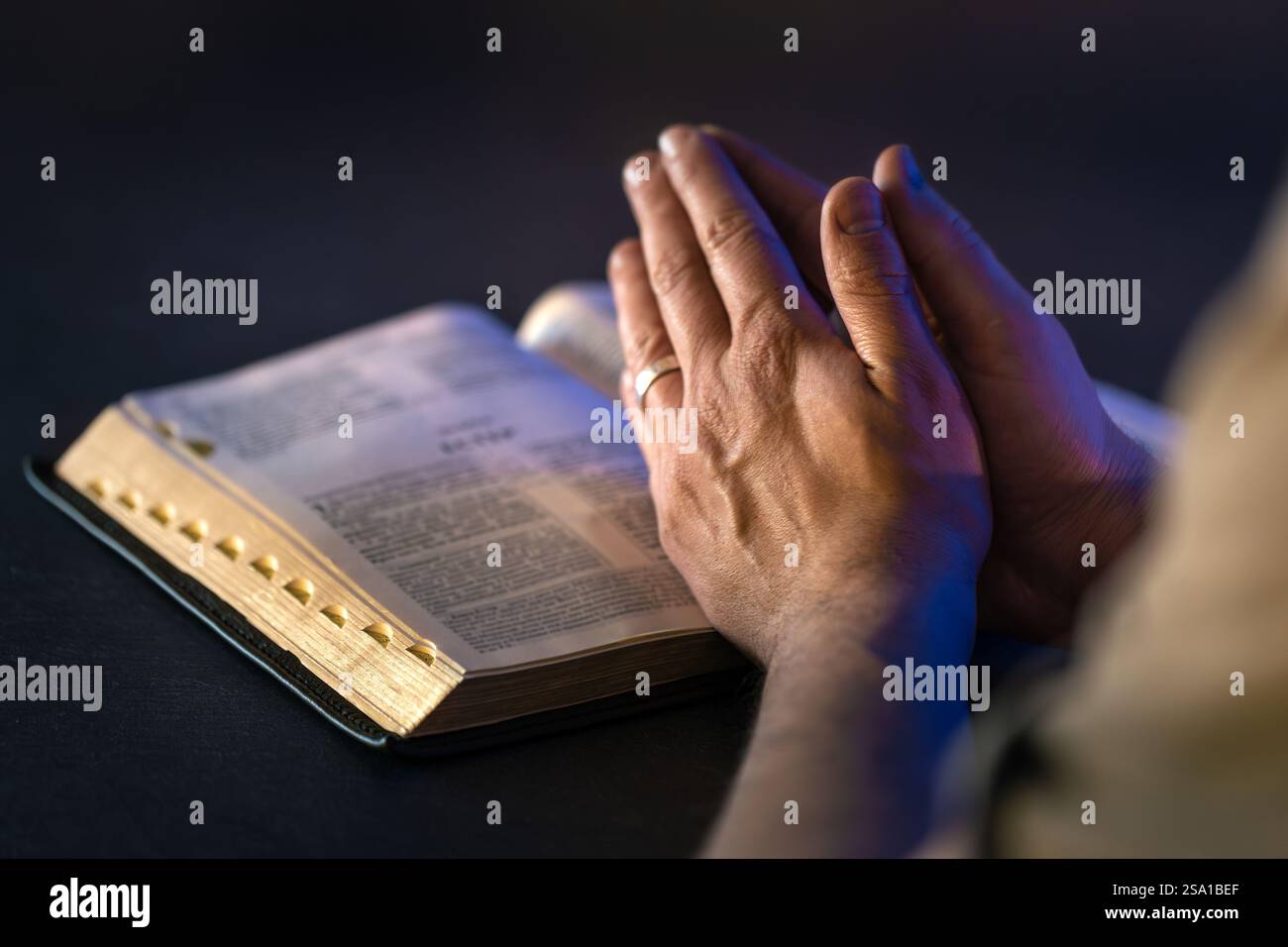 Hands on the Holy Bible. Prayer. Open Bible close-up. Religion concept ...