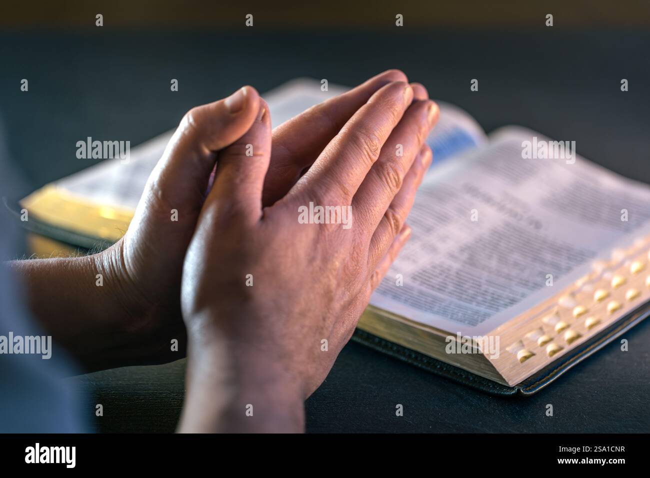 Hands on the Holy Bible. Prayer. Open Bible close-up. Religion concept ...