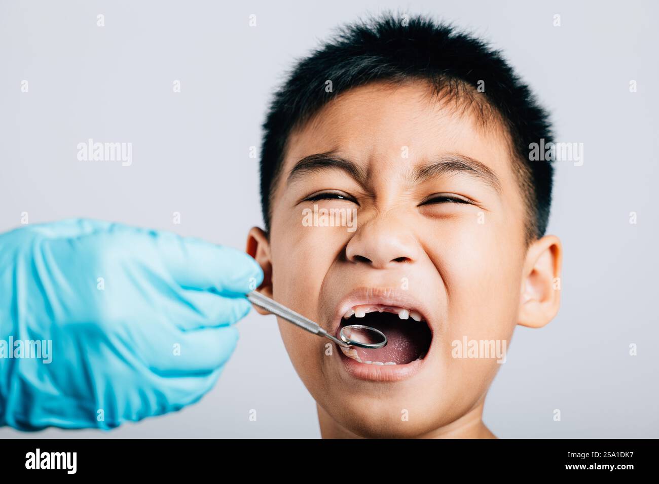 After removing a child's loose milk tooth a pediatric dentist conducts ...