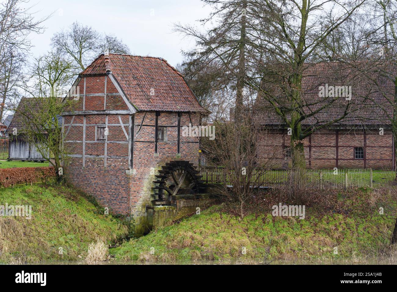 An old brick mill building with half-timbering and water wheel ...