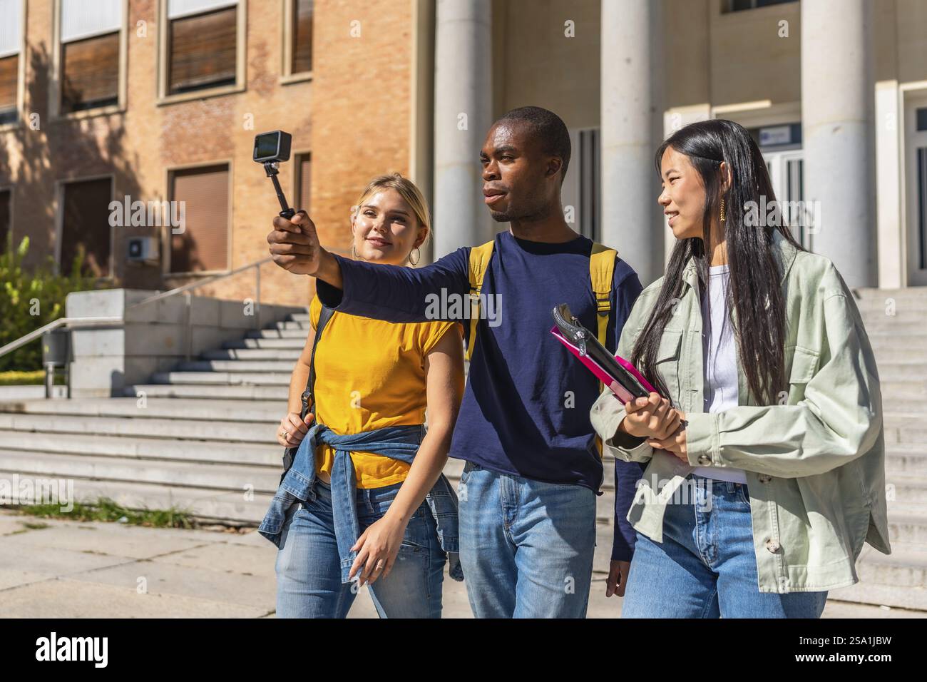 Multi-ethnic university students recording vlog with small portable ...
