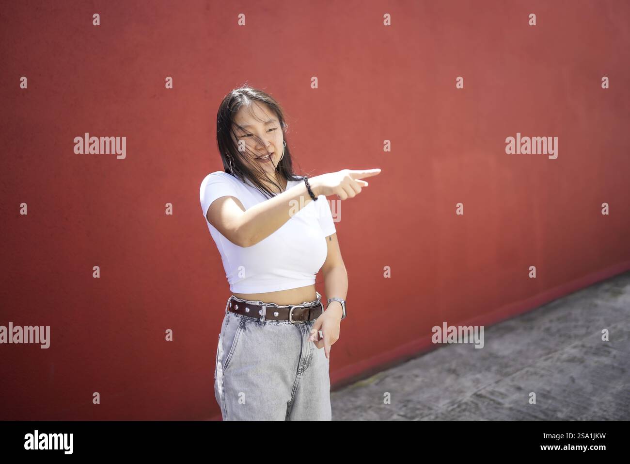 Asian woman pointing ahead while dancing K-pop korean modern dance next ...
