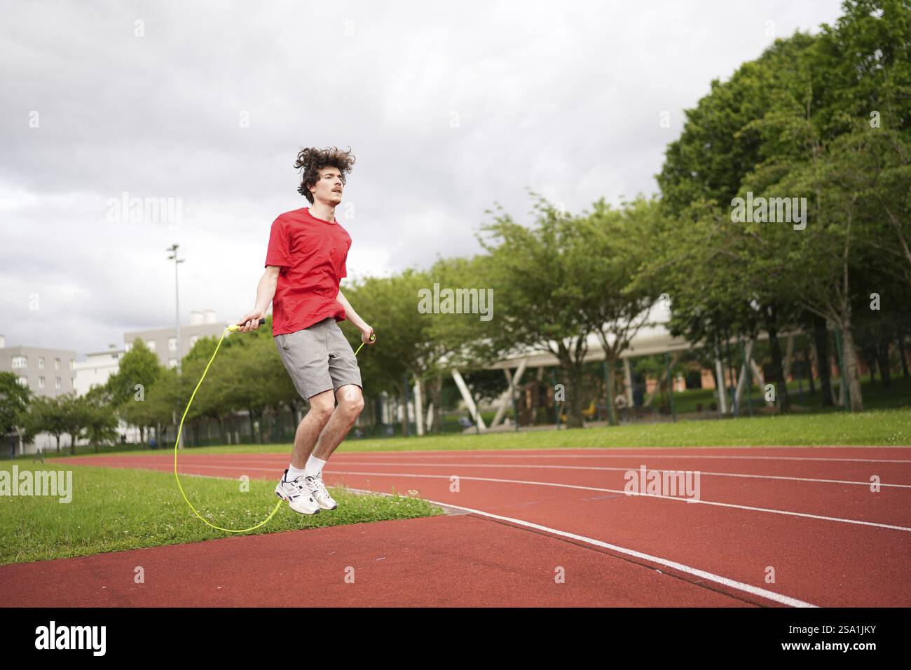 Full length photo of a young caucasian man jumping skipping rope to ...