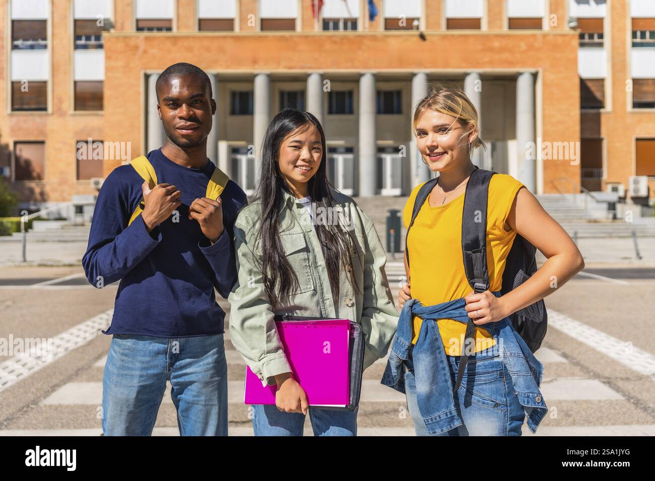 Portrait of three multi-ethnic students at the campus standing outside ...