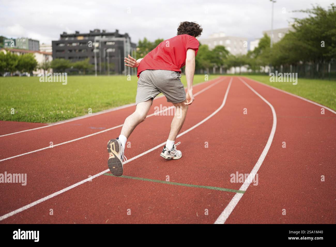 Full length rear view of a male caucasian young athlete leaving ...