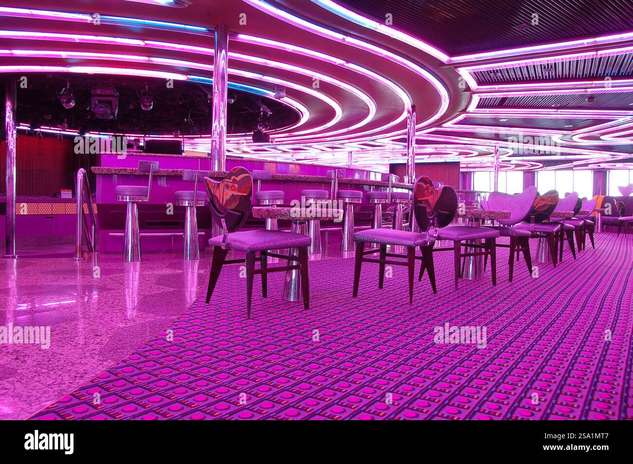 Empty bar and disco area with neon pink lights aboard a cruise ship ...