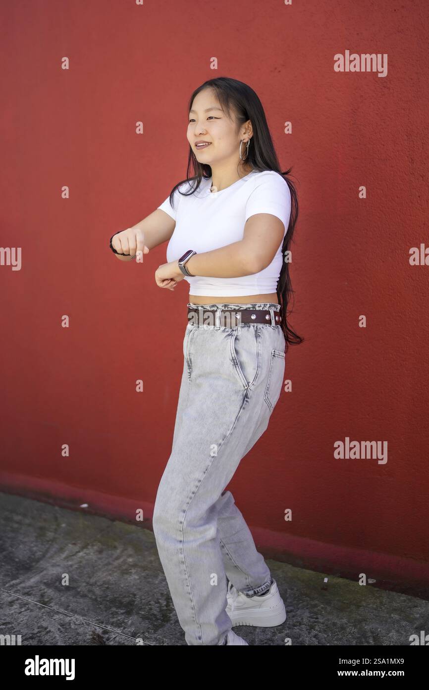 Vertical side view photo of an asian young urban woman moving arms in ...