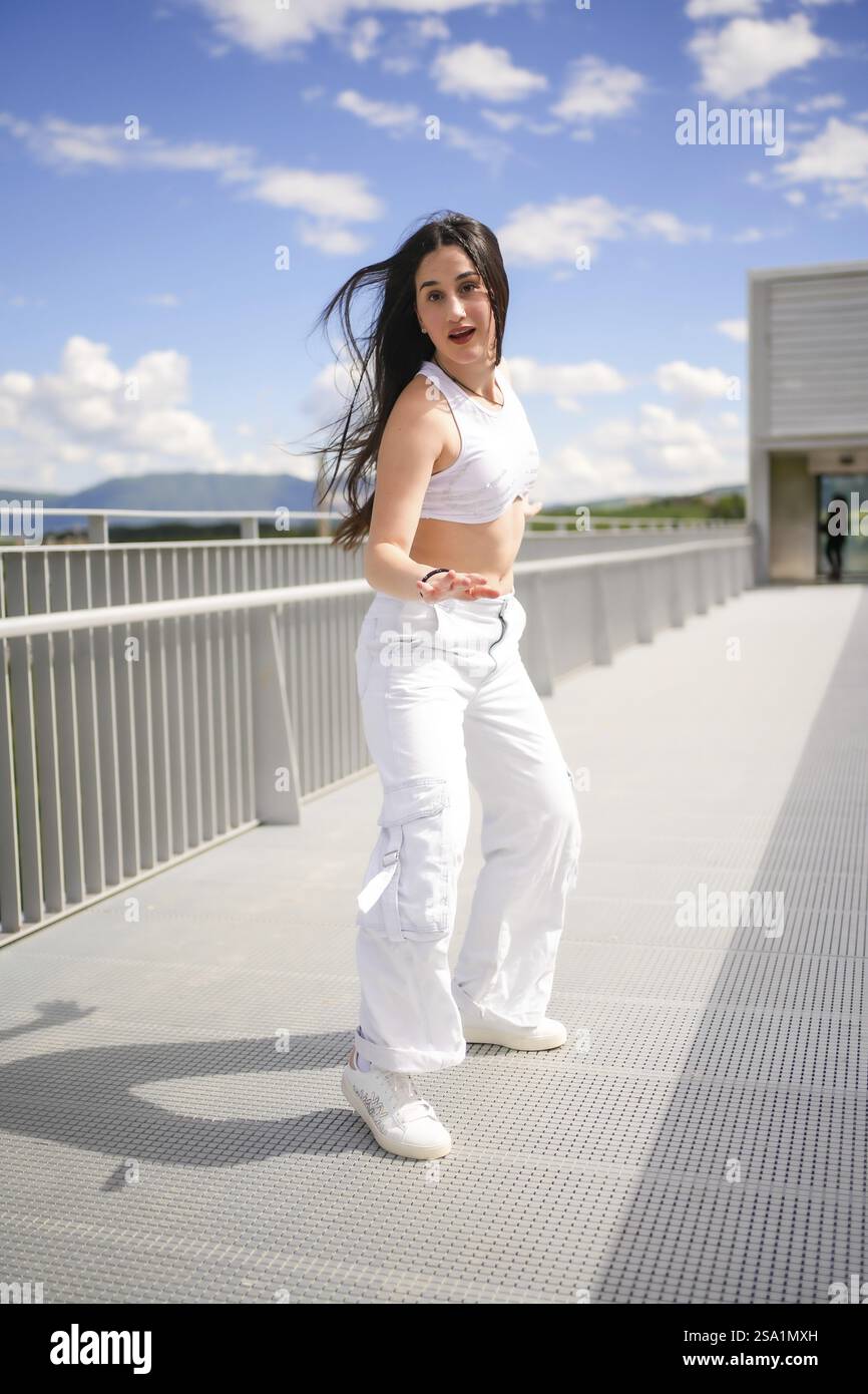 Vertical full length of a caucasian beauty young woman moving dancing ...