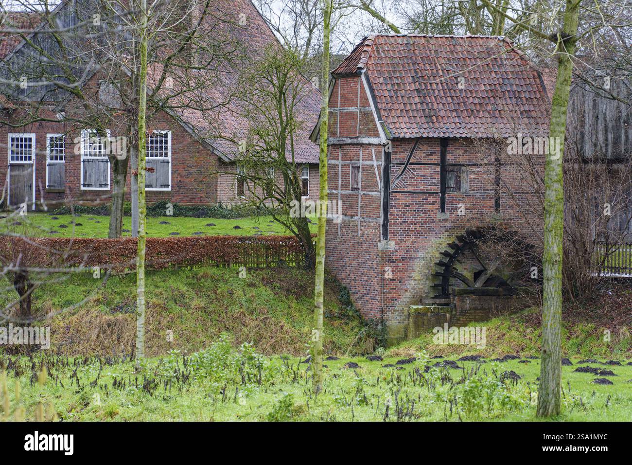 Historic water mill in half-timbered style with bricks, surrounded by ...