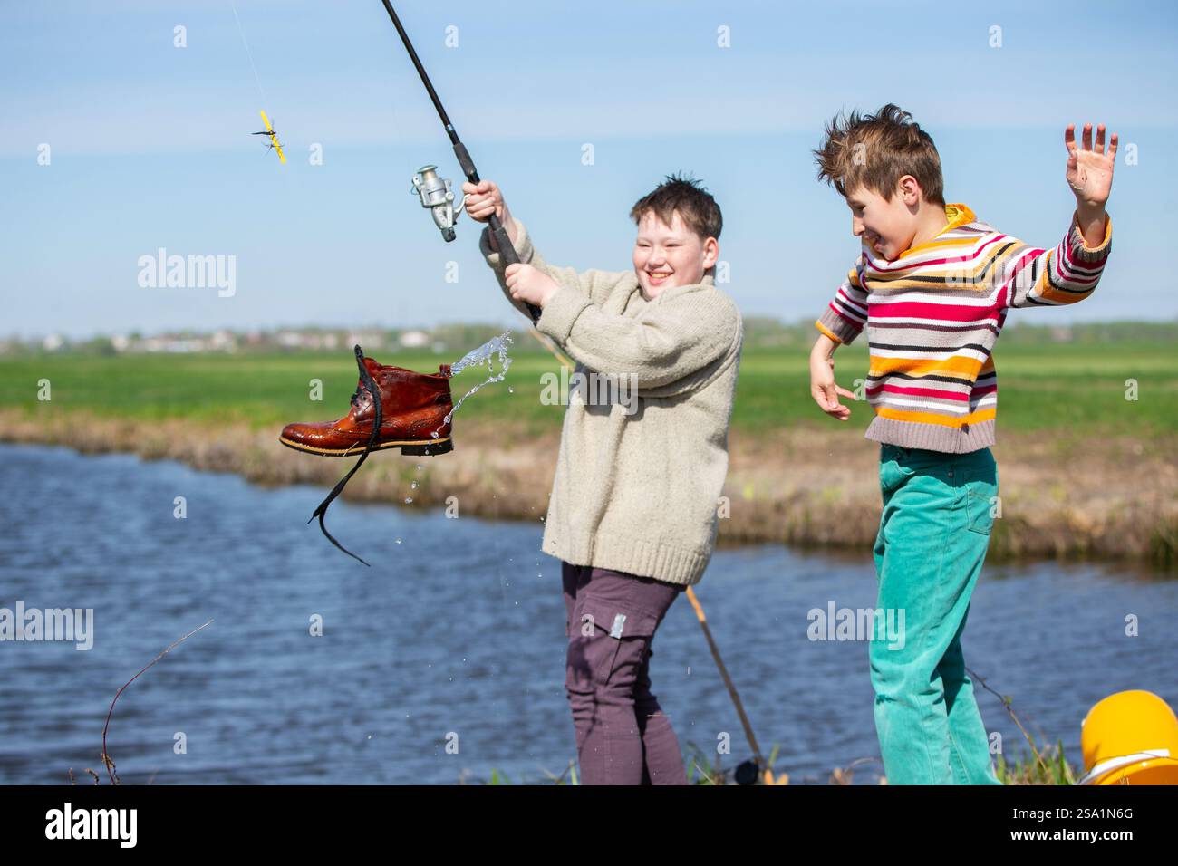 Funny fishing. Two of the boy's friends hooked an old shoe with a ...