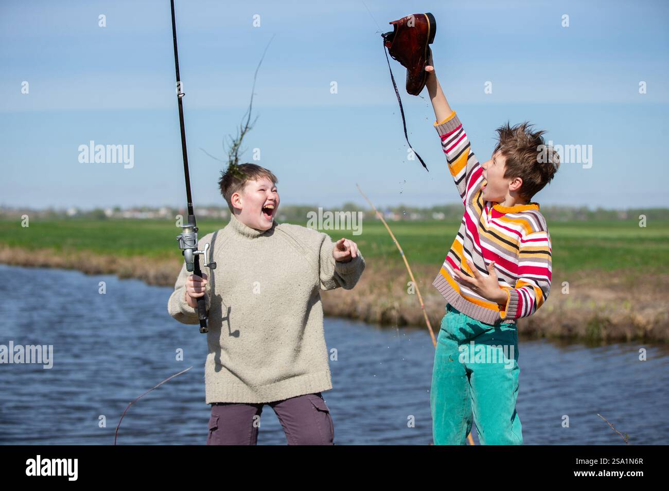 Funny fishing. Two of the boy's friends hooked an old shoe with a ...