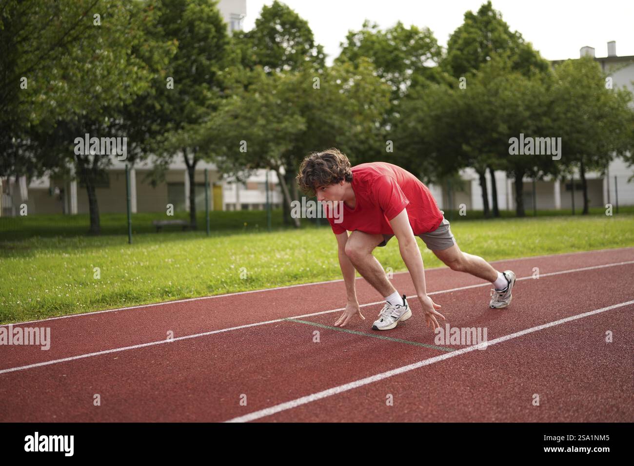 Full length of a caucasian young man in starting position in starting ...