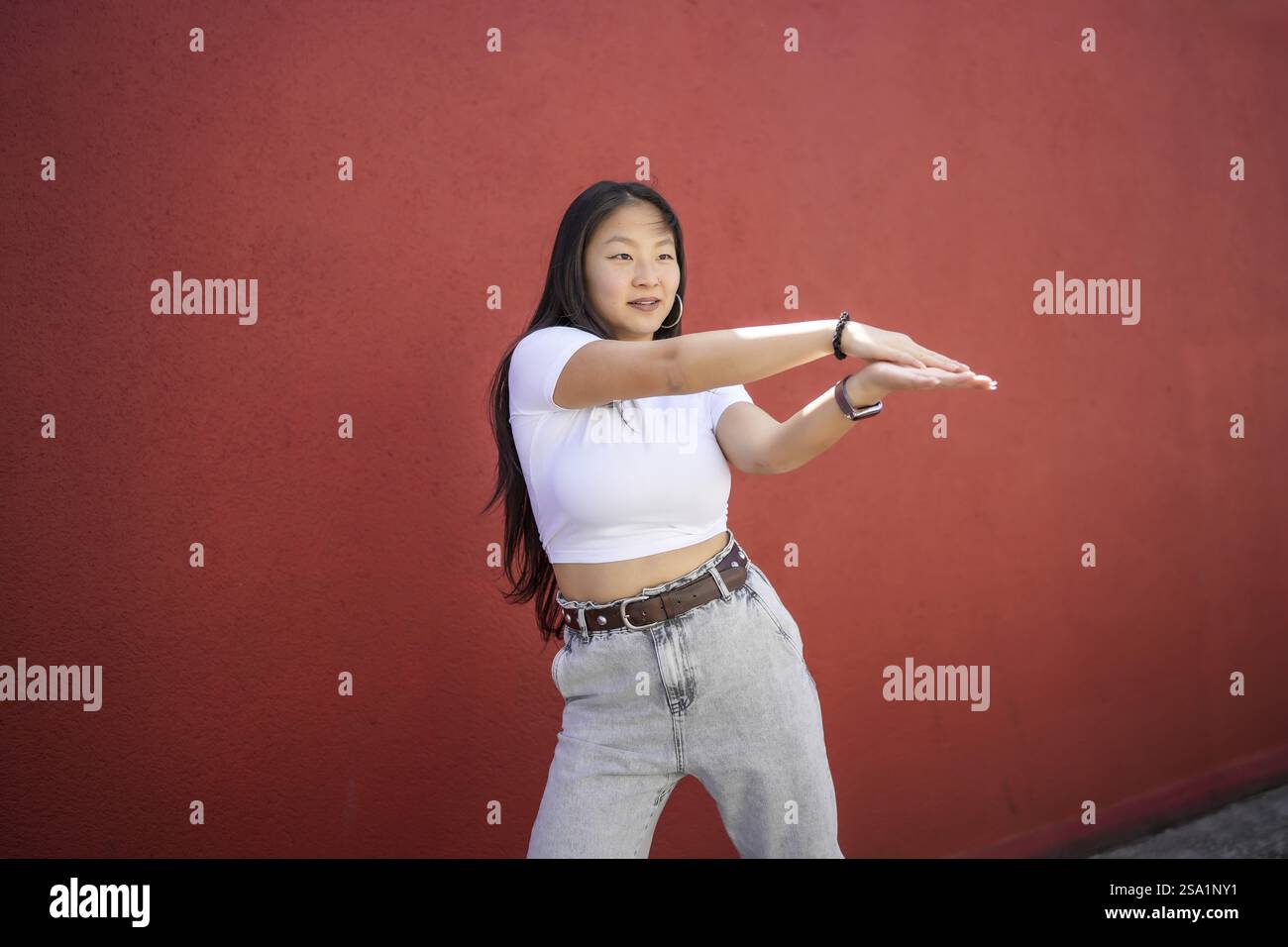 Three quarter length photo of a young Asian woman gesturing as ...