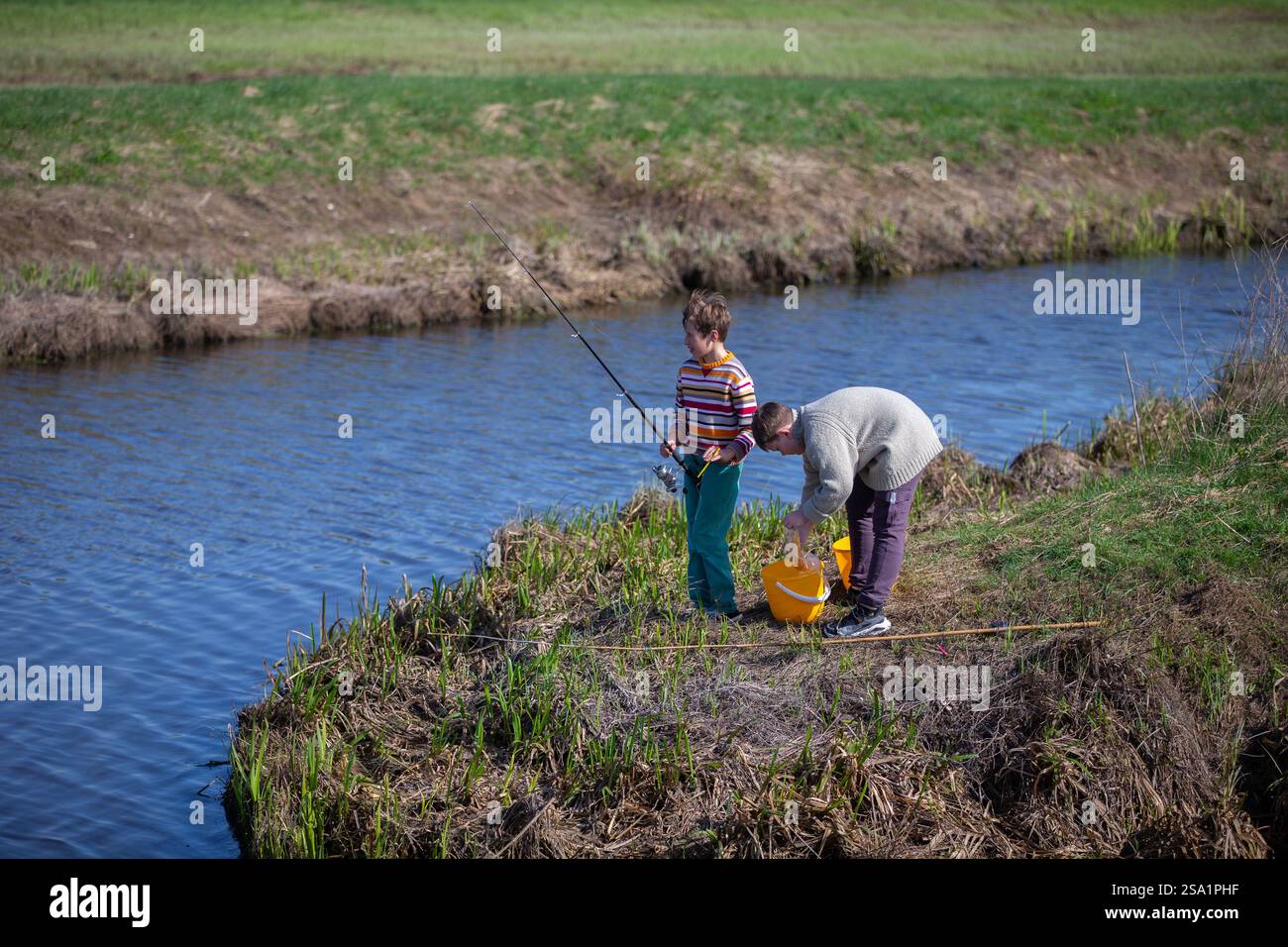 The boys are fishing on a small river. Friends go fishing in the summer ...