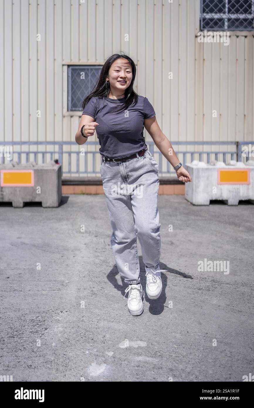 Vertical photo of a female happy young urban korean dancer jumping ...
