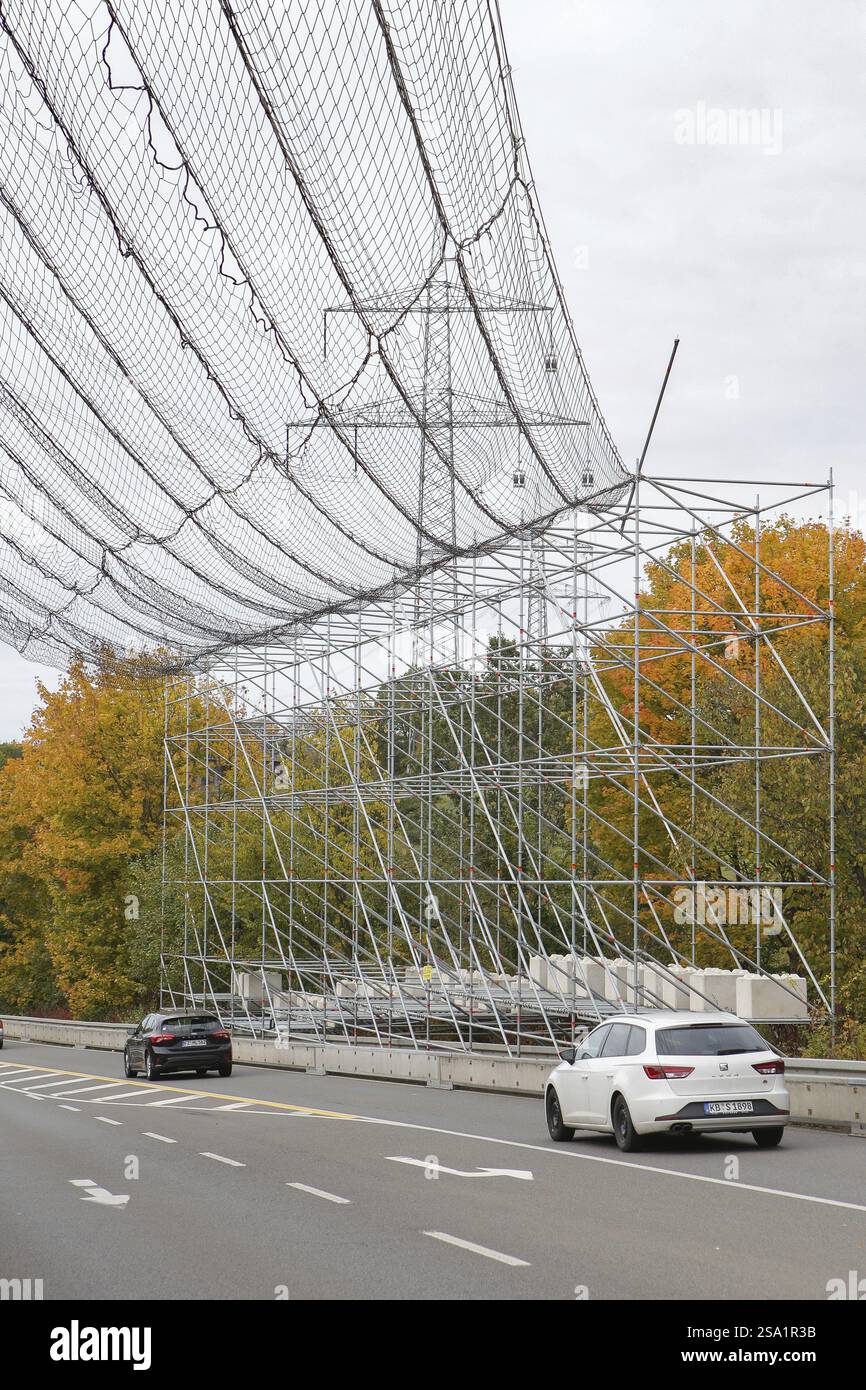 A scaffold with steel net as protection over a road with cars, safety ...