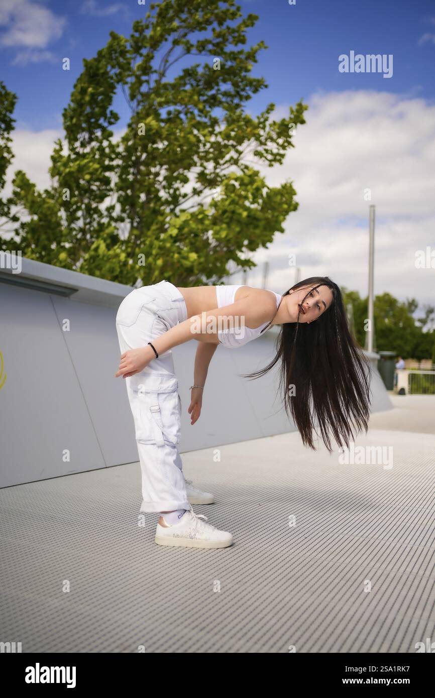 Full length vertical photo of a caucasian young woman bending to dance ...