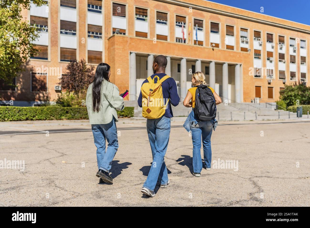 Three students walking along hi-res stock photography and images - Alamy