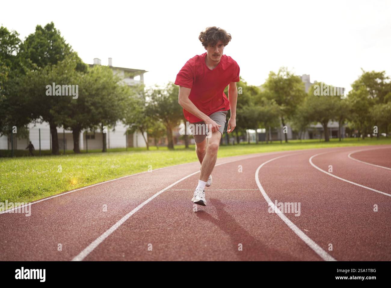 Frontal full length of a caucasin young man running along an outdoor ...
