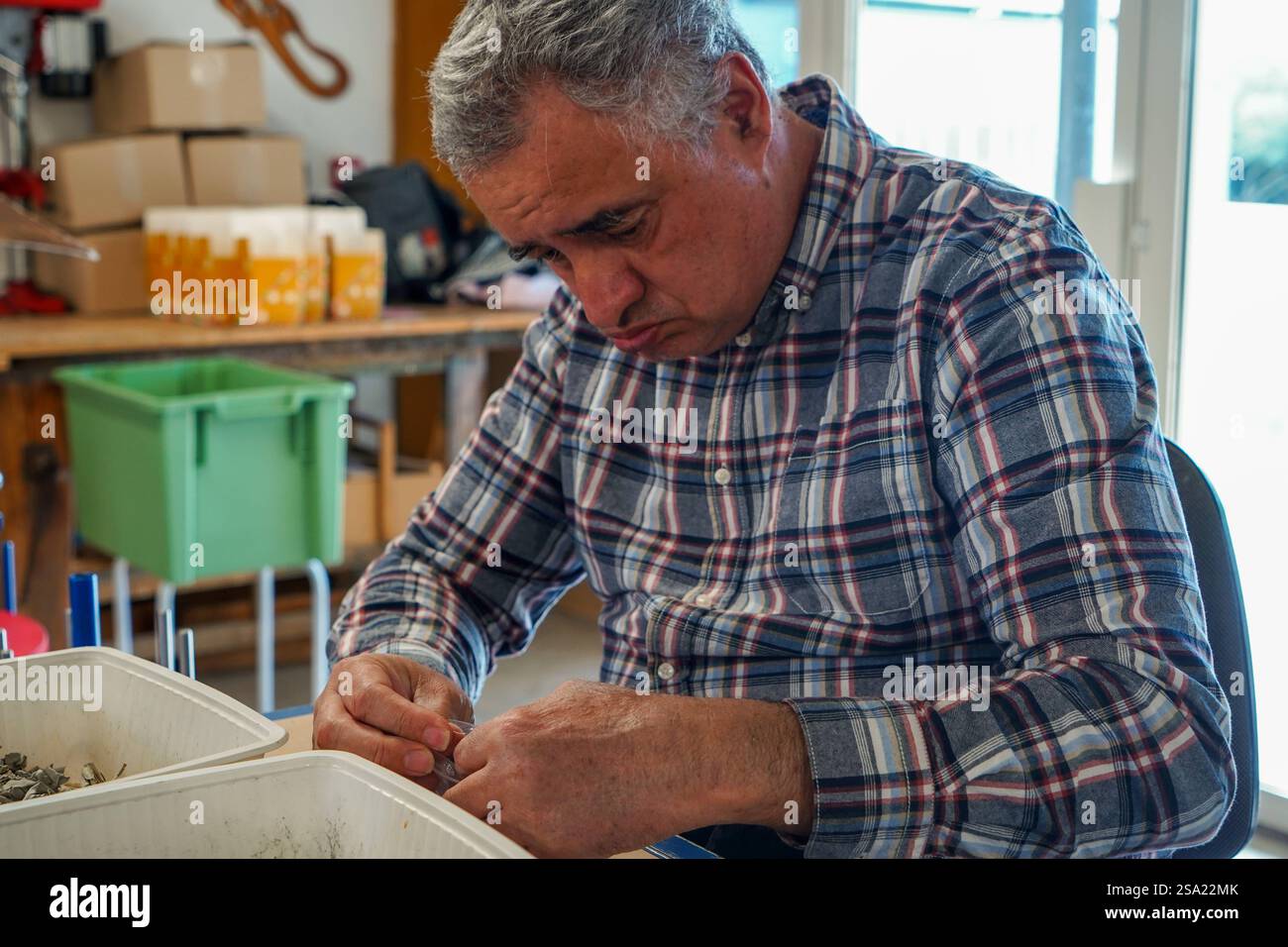 Disabled worker working in the ESAT product packaging workshop ...