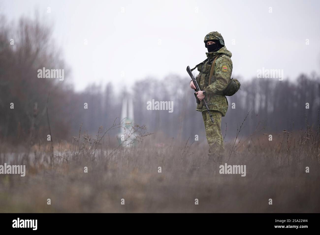 A Belarusian border guard inspects a road from Belarusian border ...