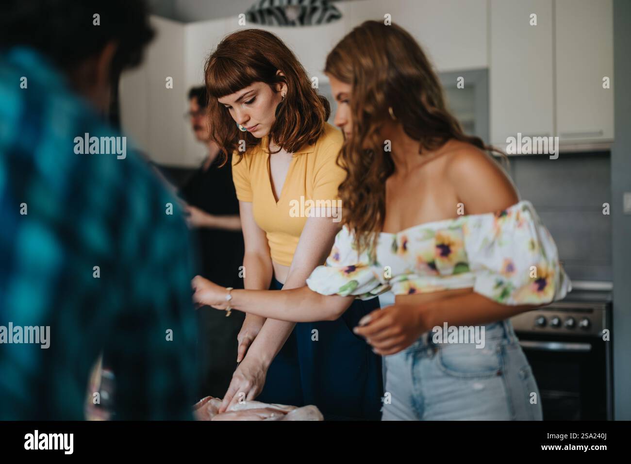 Women preparing meal together in a modern kitchen setting Stock Photo ...