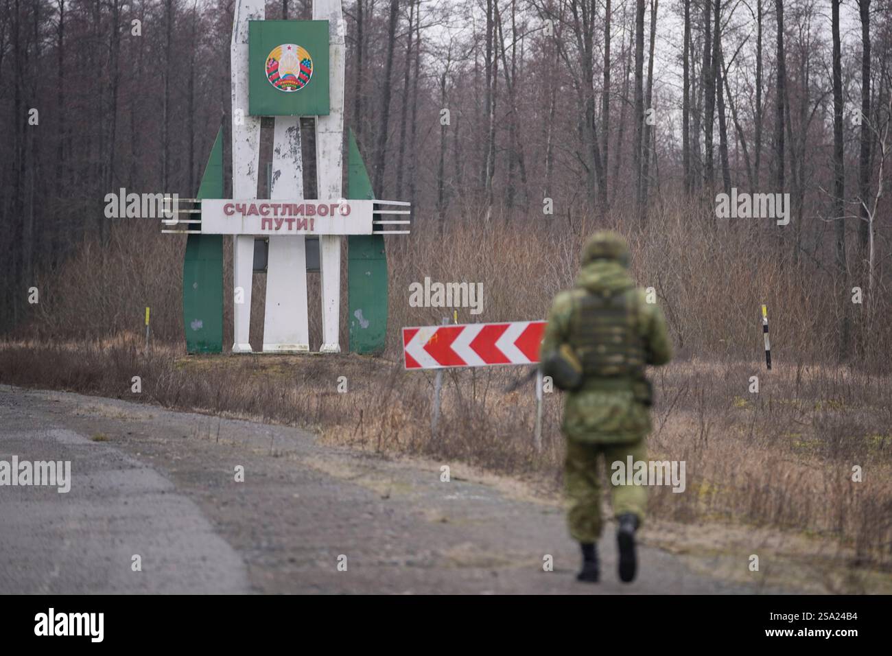 A Belarusian border guard inspects a road from Belarusian border ...