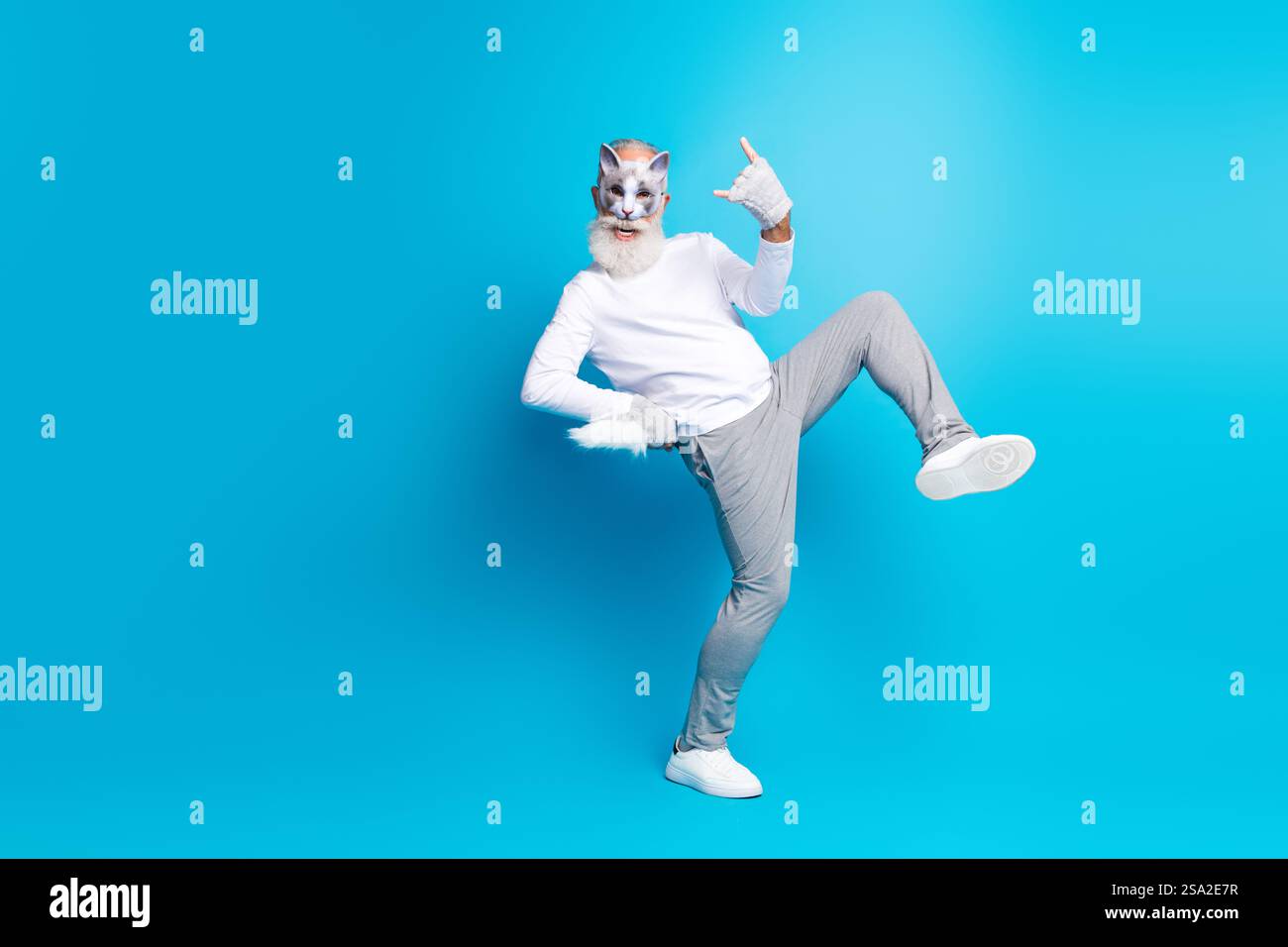 Elderly man cosplaying as a feline-themed character strikes a playful ...