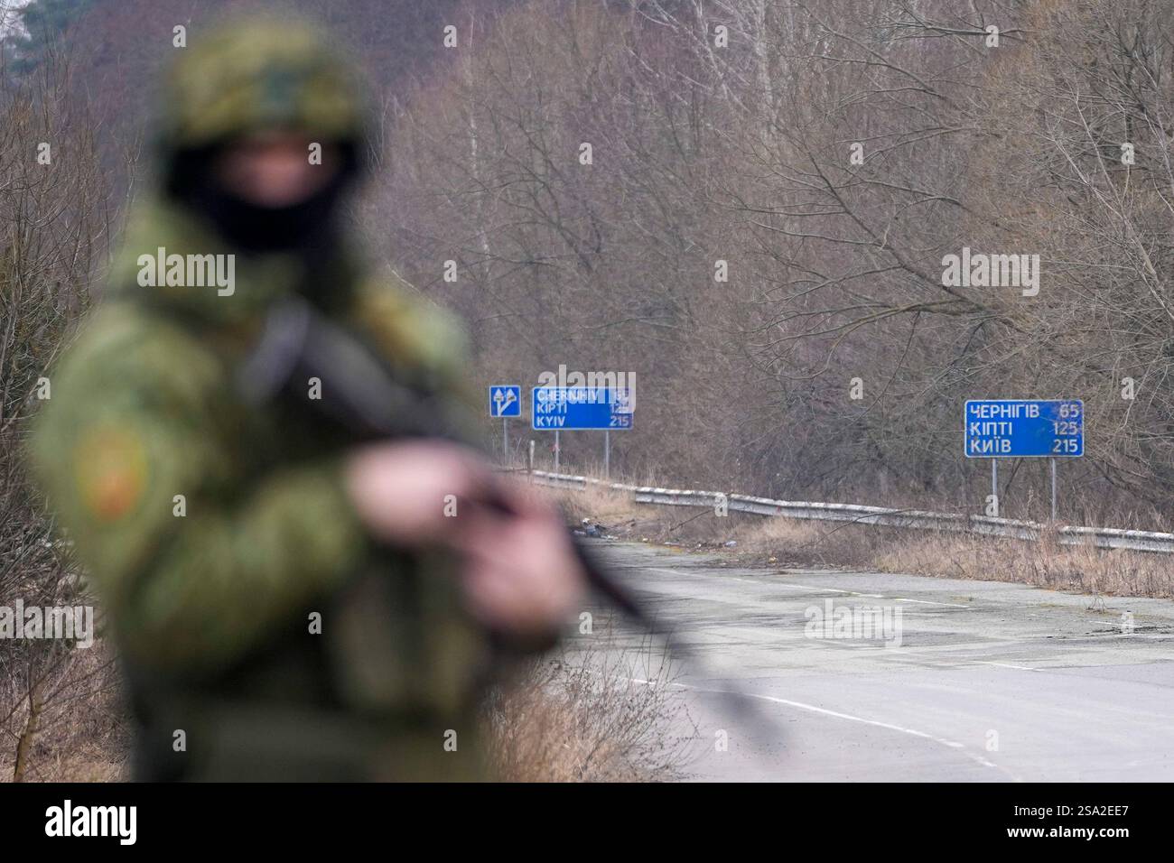 A Belarusian border guard inspects a road outside of Ukrainian border ...