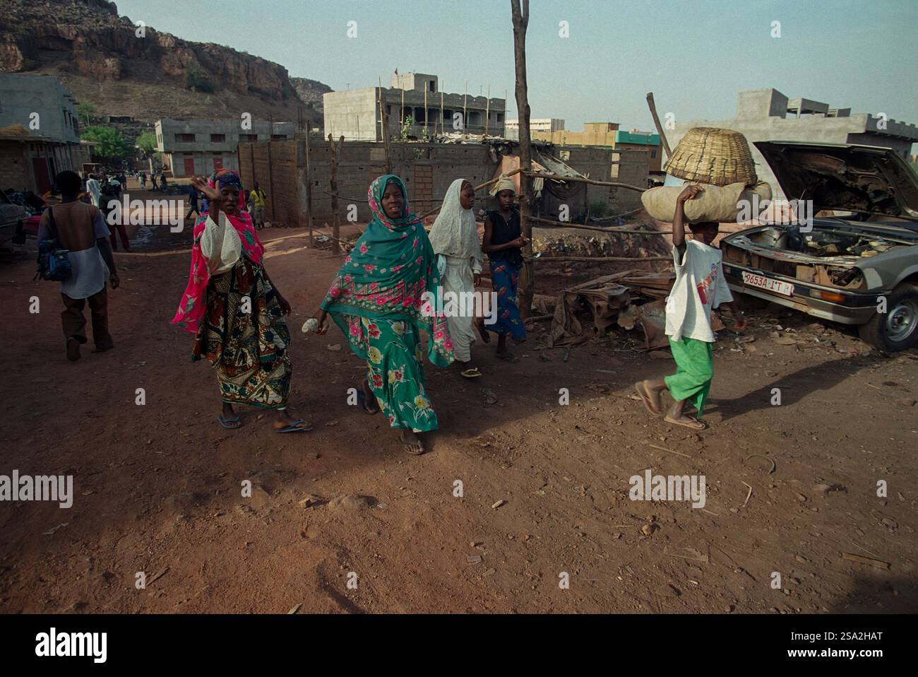 Islamic African women making their way along a back street in Bamako ...