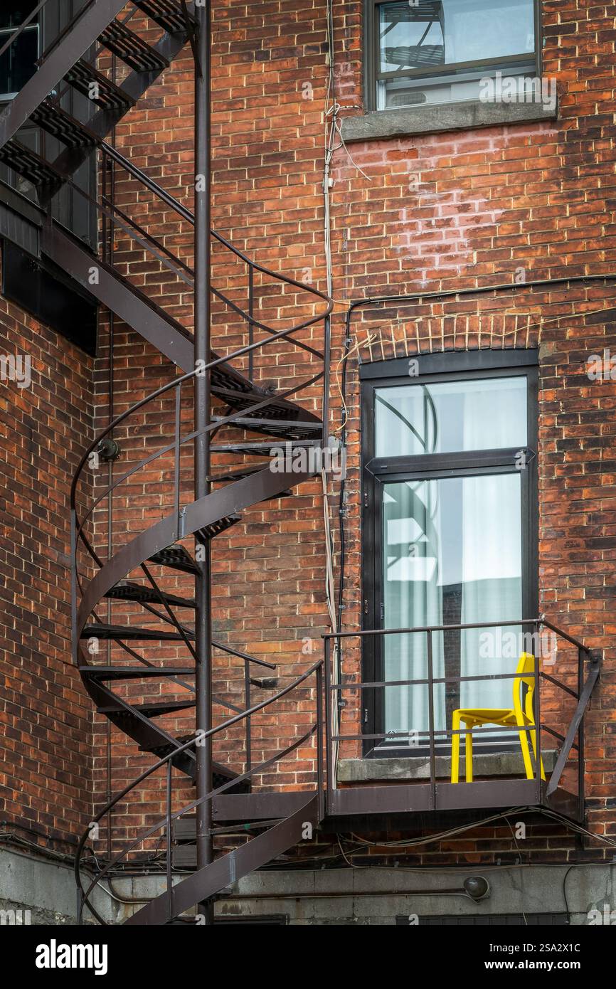Rusty metallic outside spiral stairs on a brick building in Montreal ...