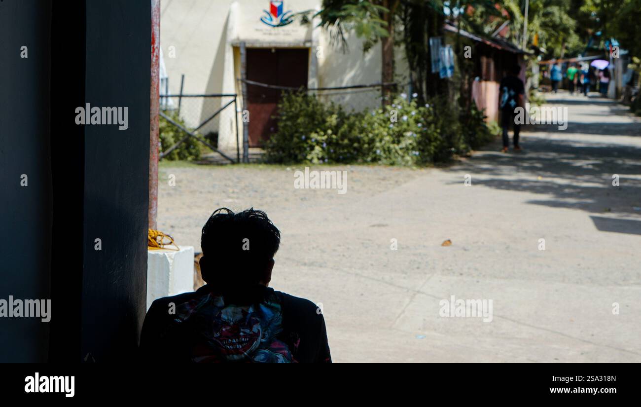 A man stands quietly watching the street in Barangay Bay-ang, Iloilo ...