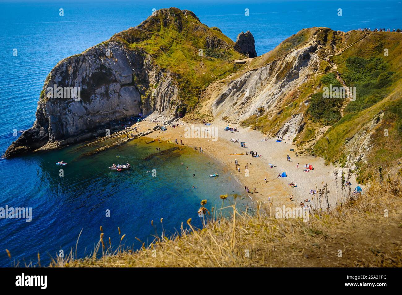 A high-angle view of Durdle Door beach in Dorset, England. Many people ...