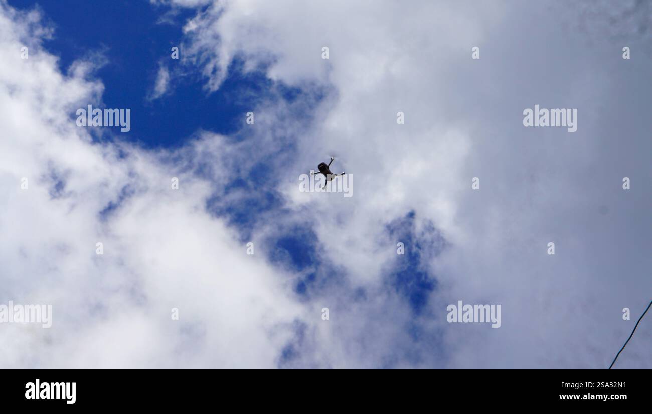 A small drone soars against a clear blue sky, showcasing precision and ...