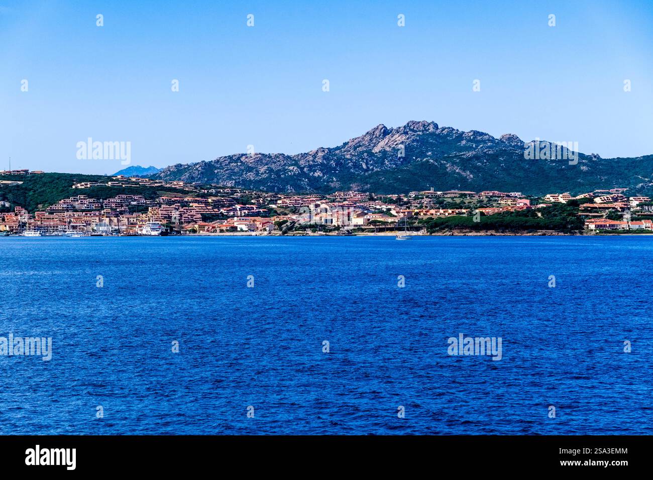The houses of the town of Palau, a rocky ridge in the distance, seen ...