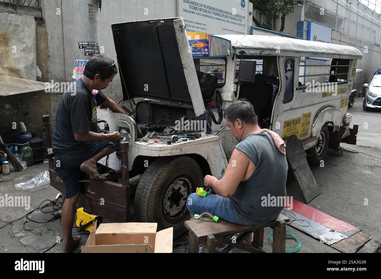 PHILIPPINES, Manila, Quezon City, Jeepney repair workshop on the road Stock Photo - Alamy