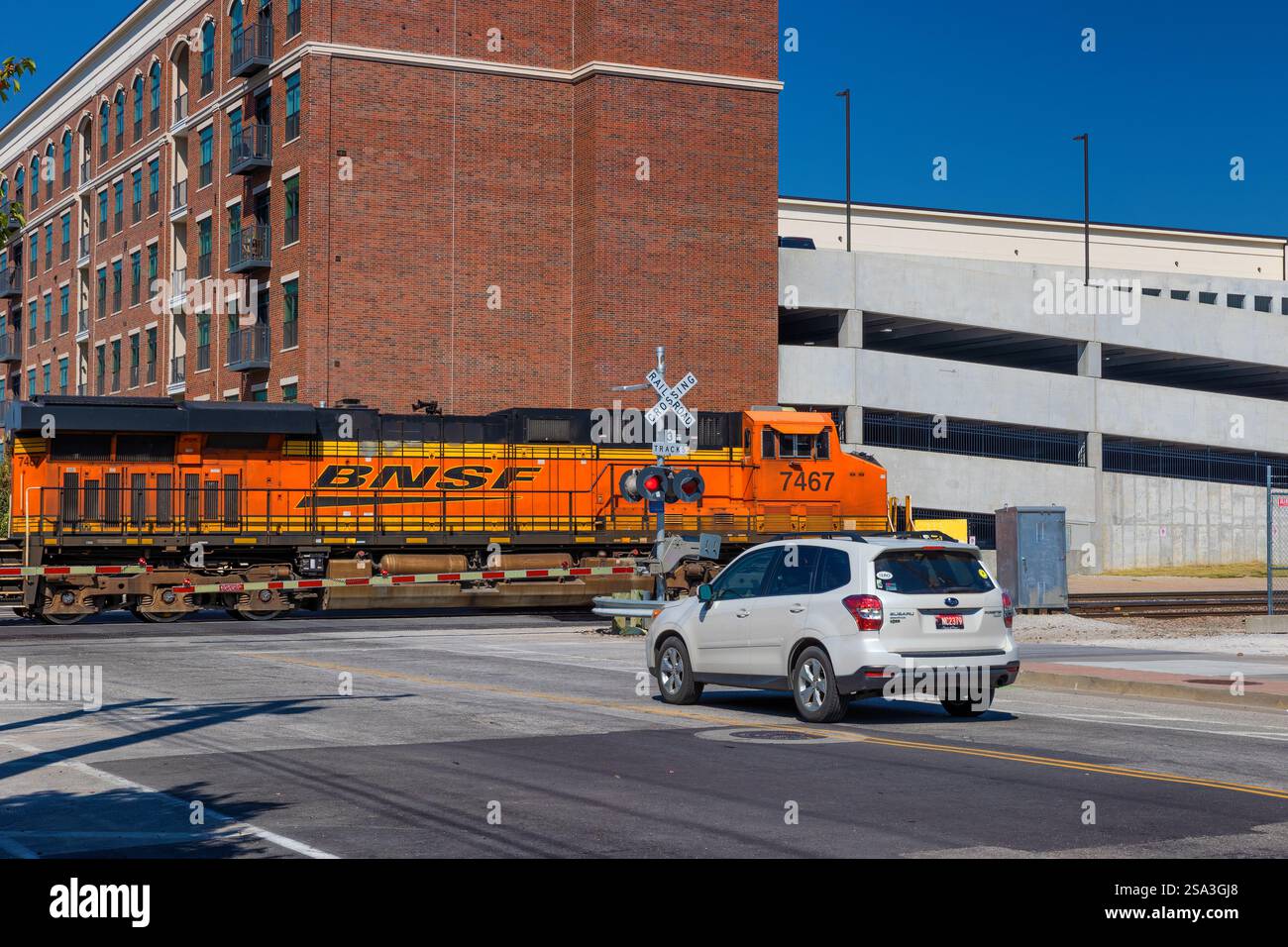 Tulsa, Oklahoma, USA - October 10, 2024: Car waits at a train crossing ...