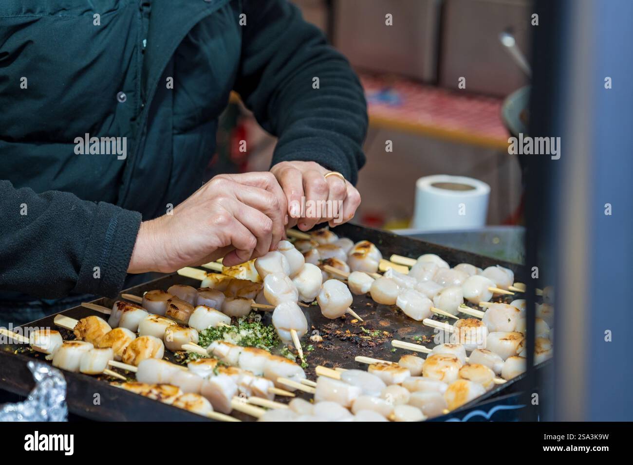 Savory street delicacies being prepared at a bustling market stall ...