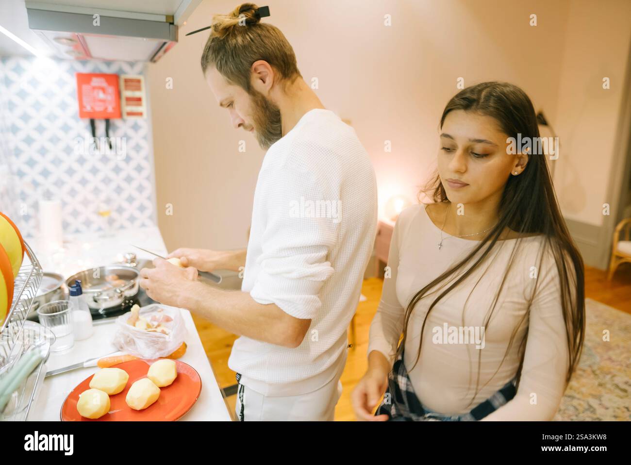 A couple happily cooking together in a beautifully modern kitchen with ...