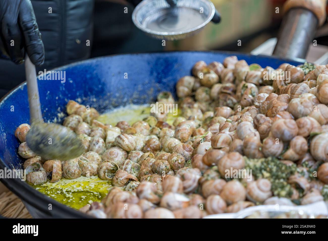 Savory preparation of escargot in a vibrant food market at sunset Stock ...