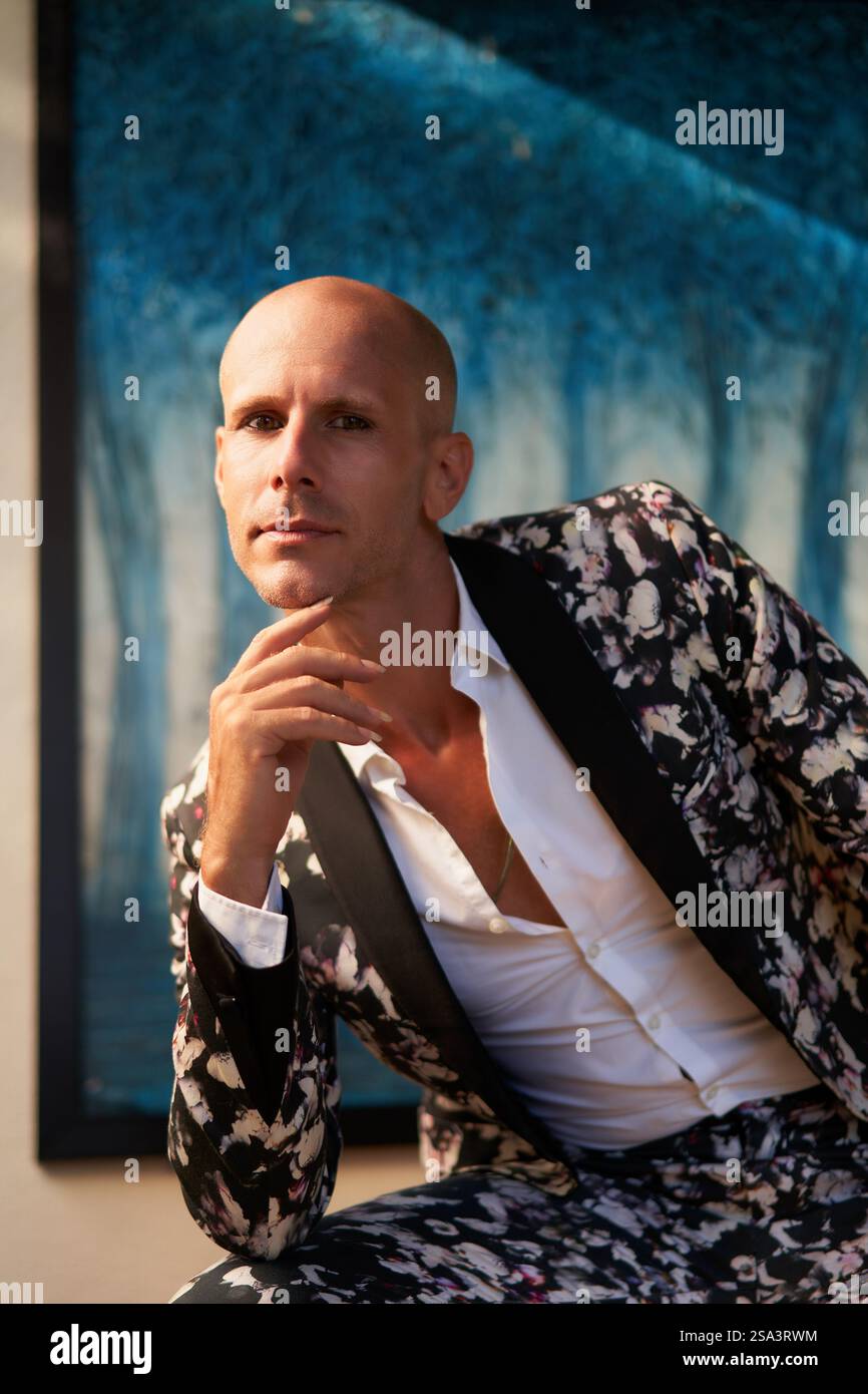 Bald man in floral suit sits at luxury villa. Classy bold gay groom ...