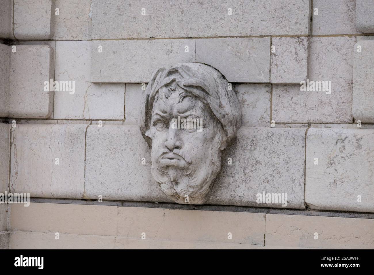 Sculpted stone face embedded in the wall reveals historical ...
