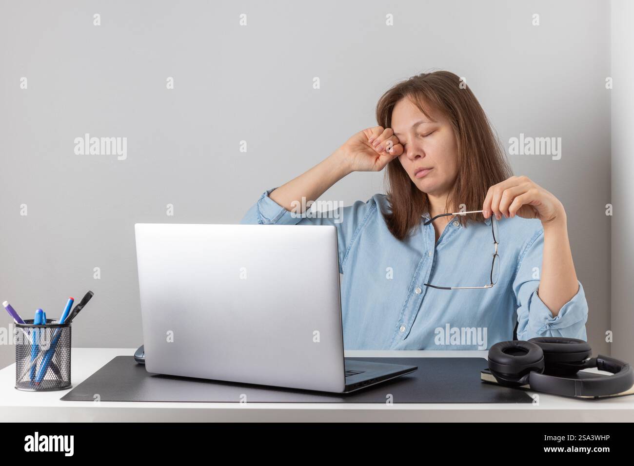 Fatigued young woman taking off glasses tired of computer work ...