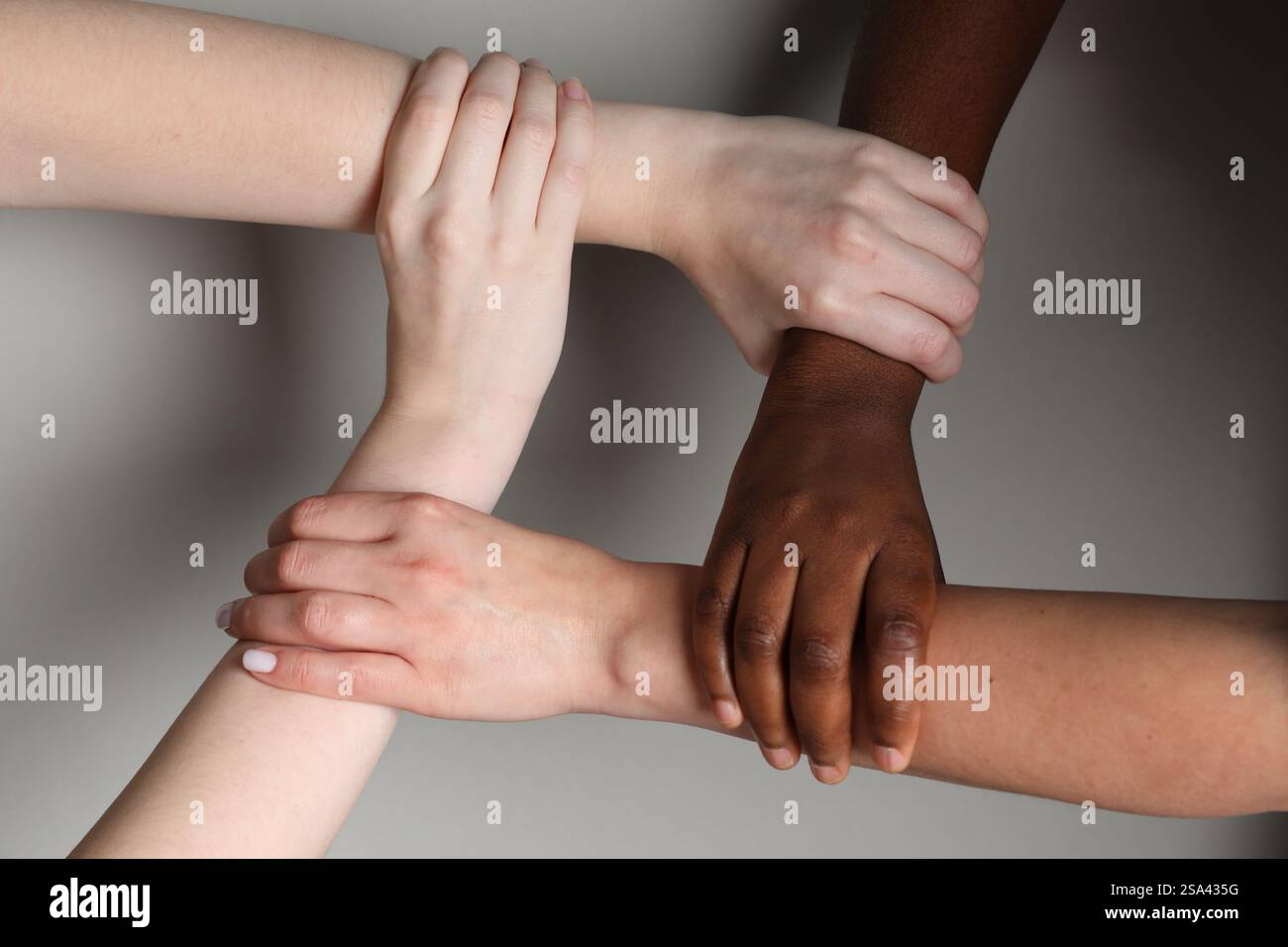 Stop racism. People of different skin colors joining hands on light ...
