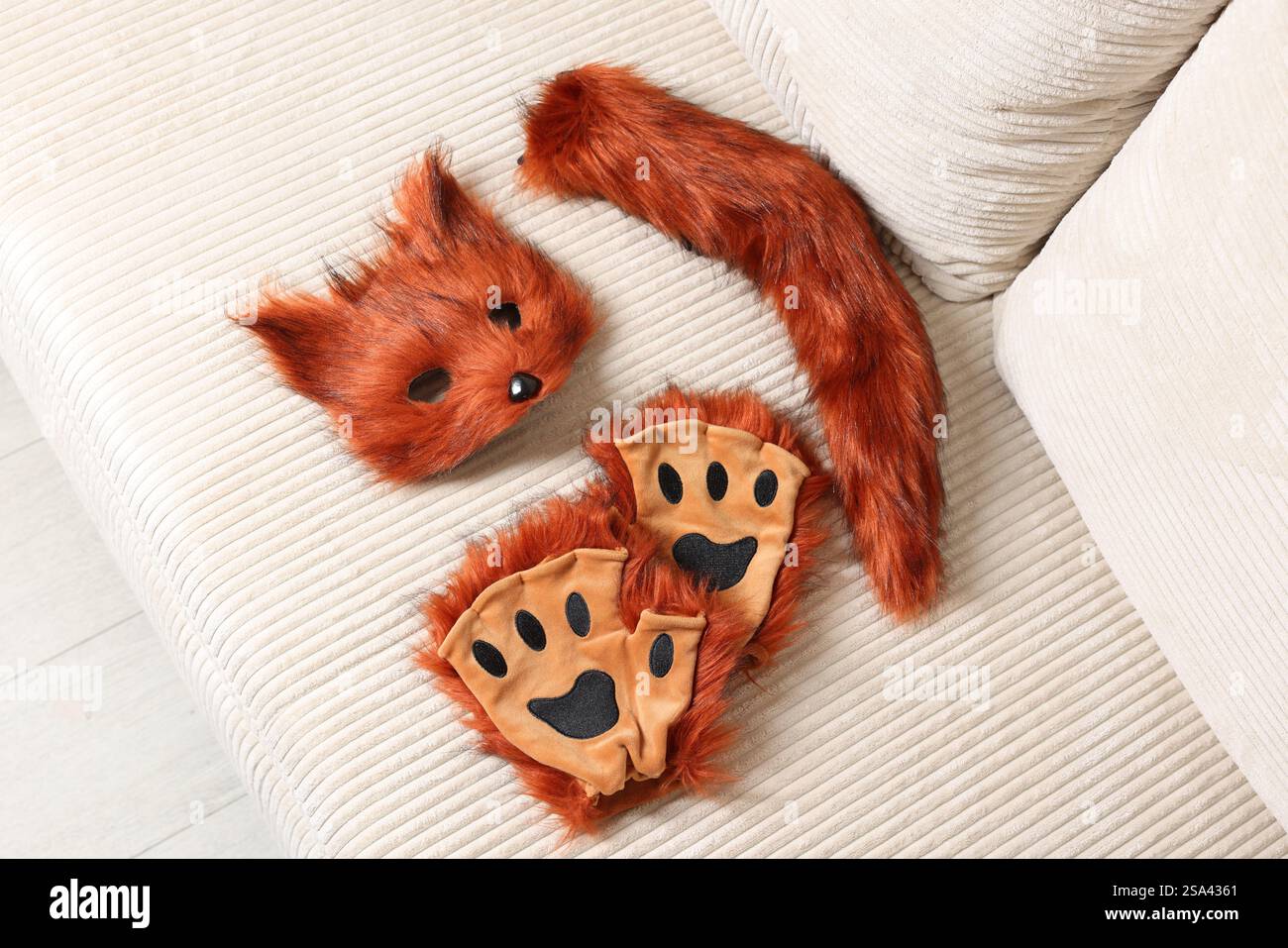 Quadrobics. Fox mask, gloves and tail on sofa, top view Stock Photo - Alamy