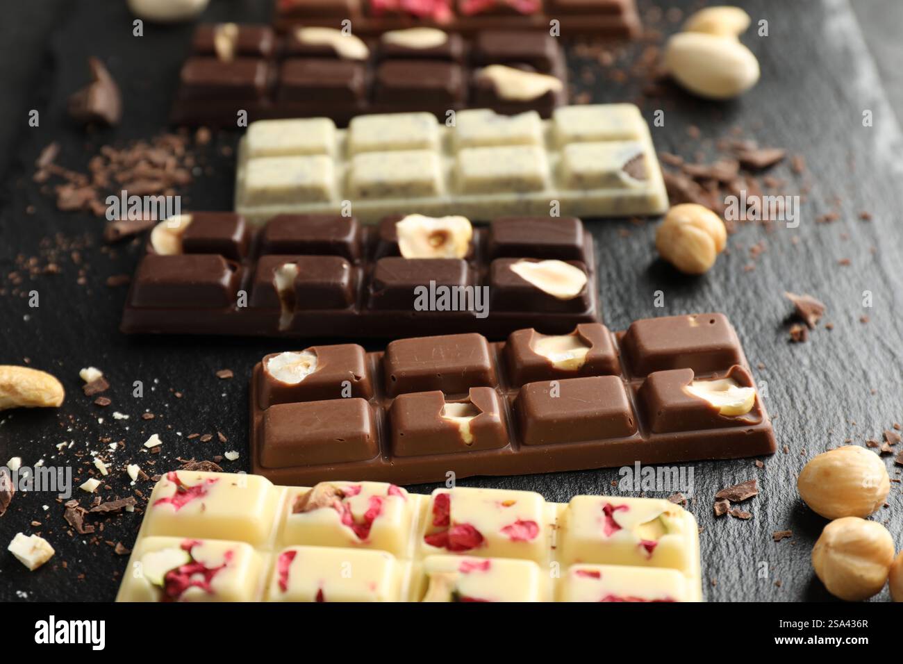 Different tasty chocolate bars with nuts and freeze dried raspberry on ...