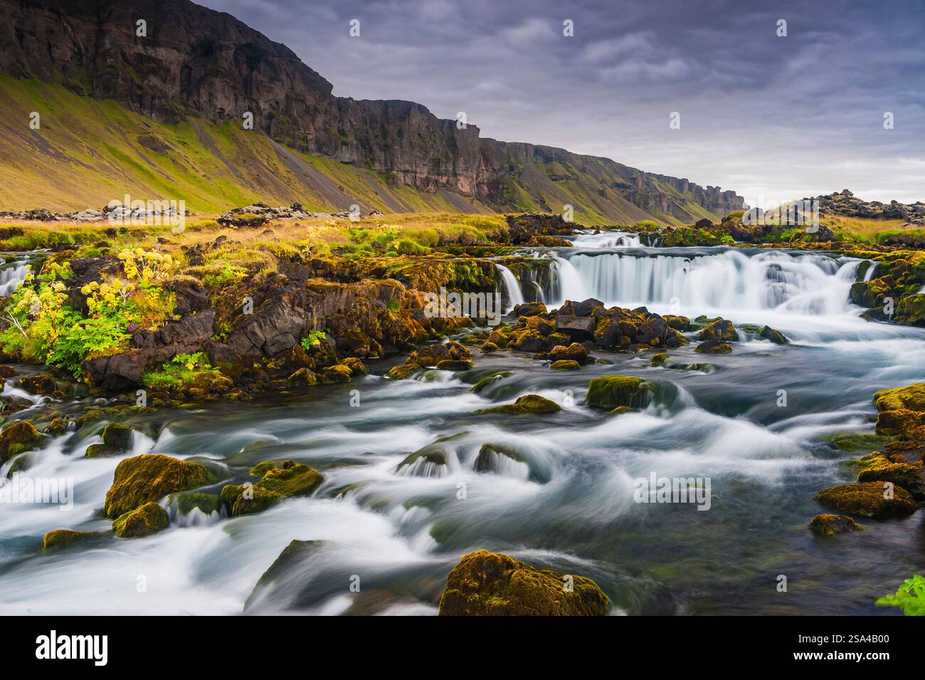 Rolling rapids cascade over rocky outcrops, surrounded by lush greenery ...