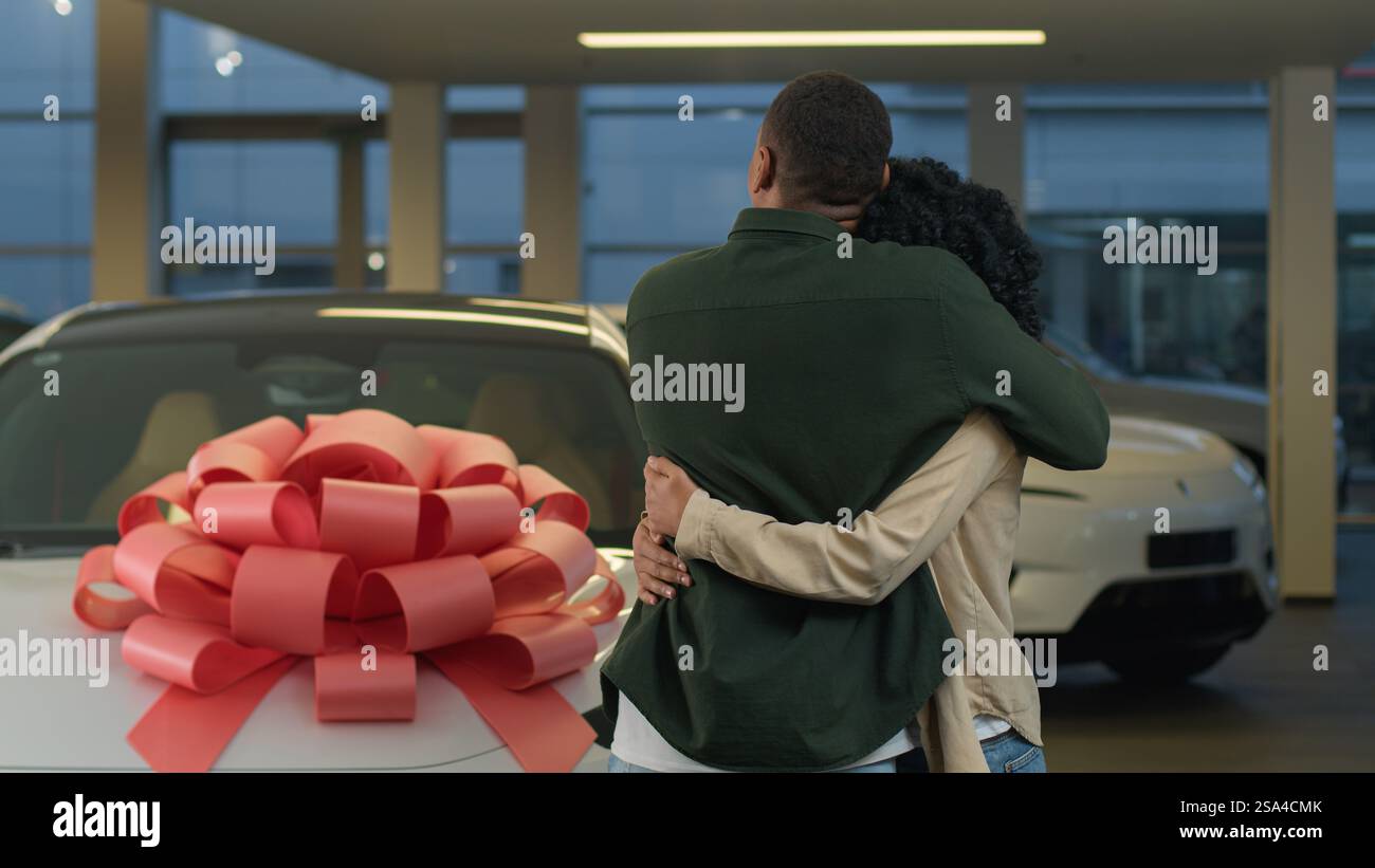 Back view African American family couple woman man in dealership store ...