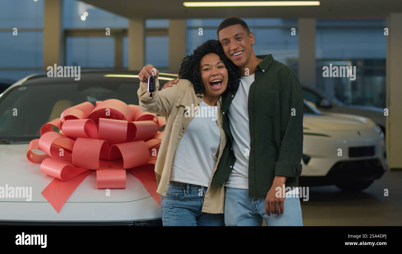 Happy smiling couple African American family woman man new car owners ...
