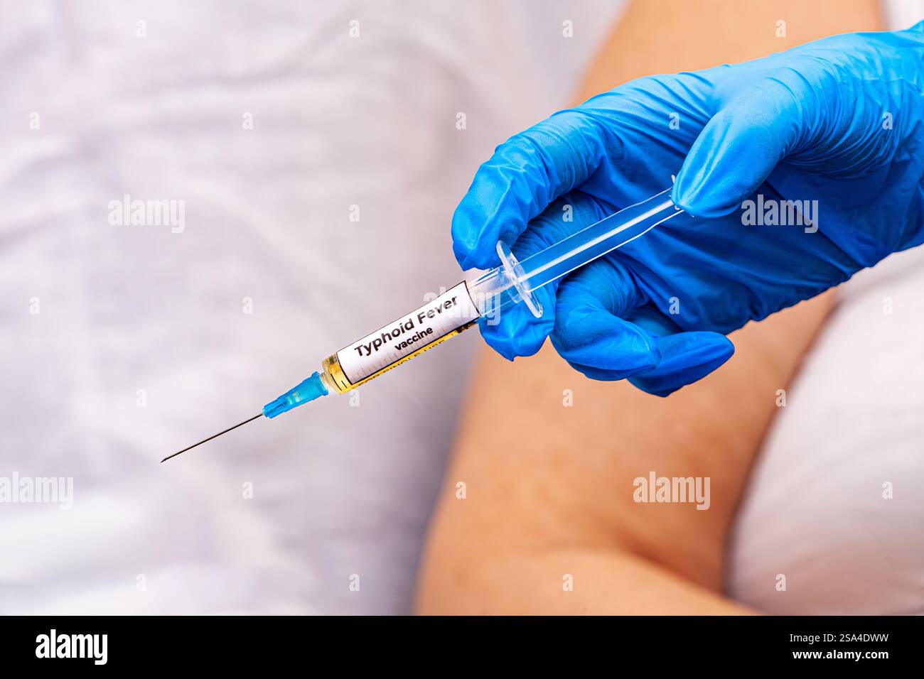 The picture shows a doctor holding a syringe with the typhoid fever ...